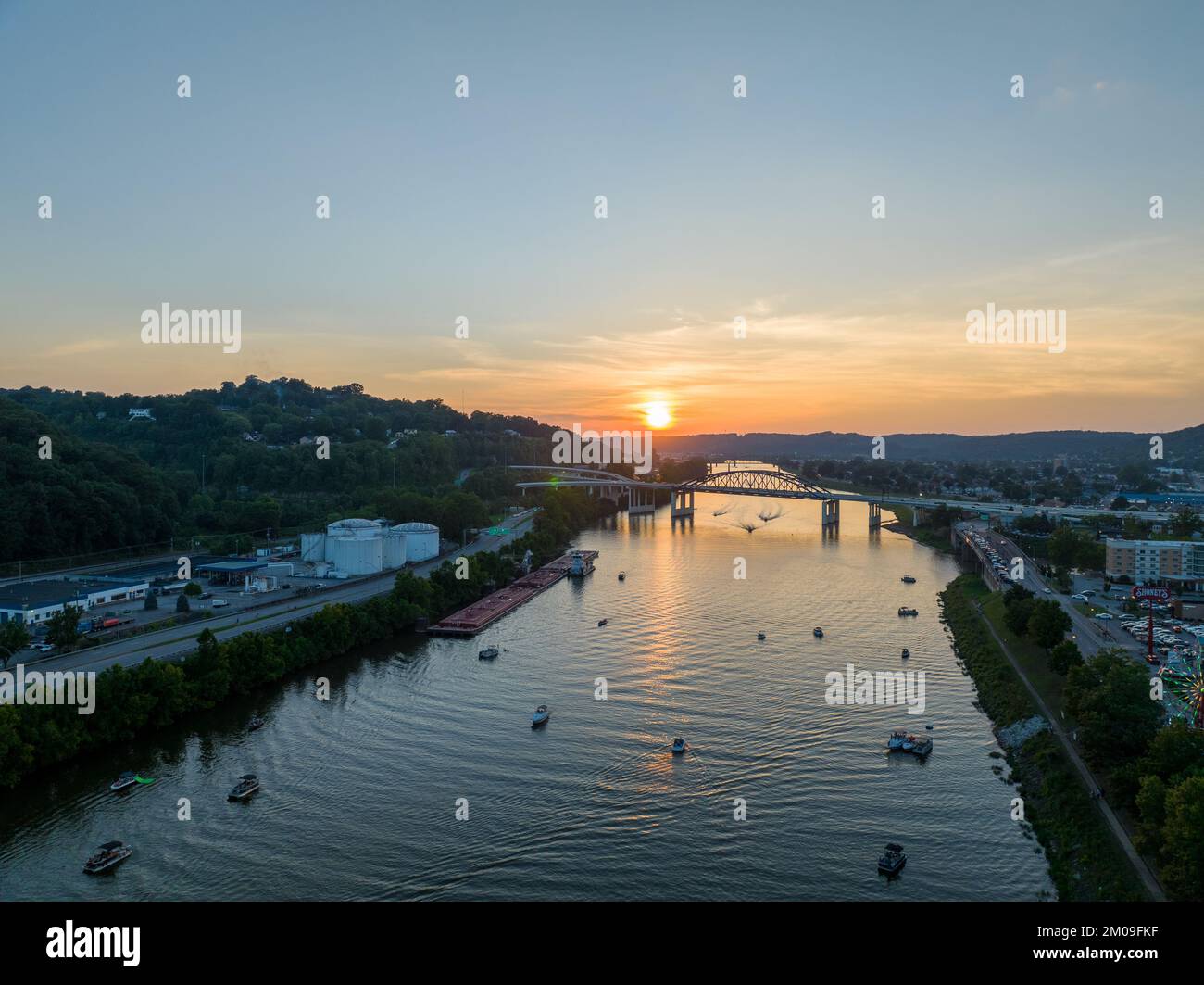 An aerial view of the sun setting behind boaters on the river Stock ...
