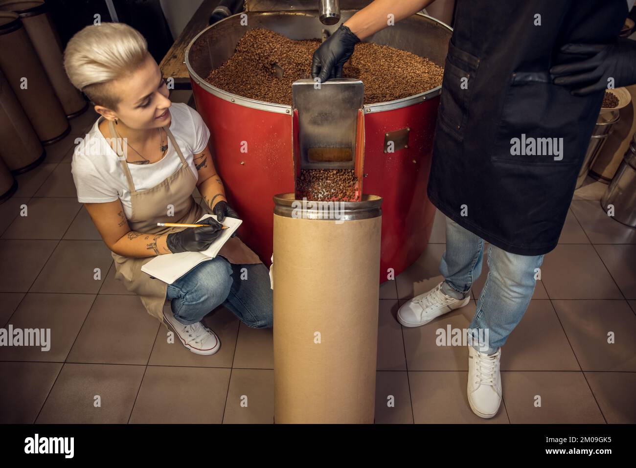 Female coffee roaster and her colleague engaged in work Stock Photo - Alamy