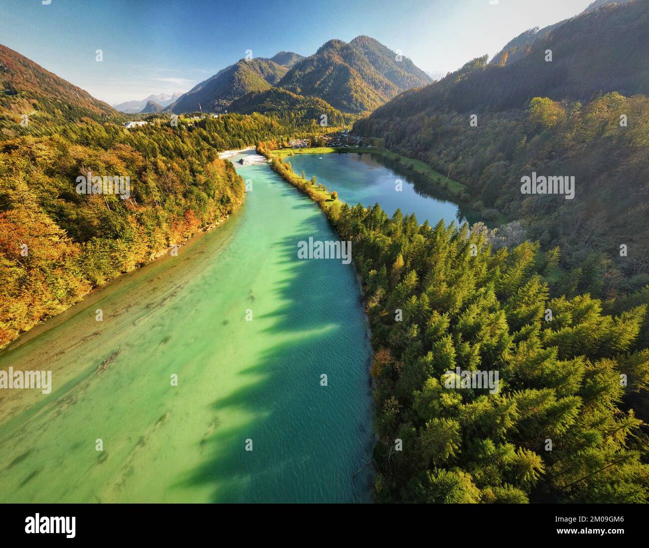 An aerial view of Steyr river flowing dense lush forests in Austria ...