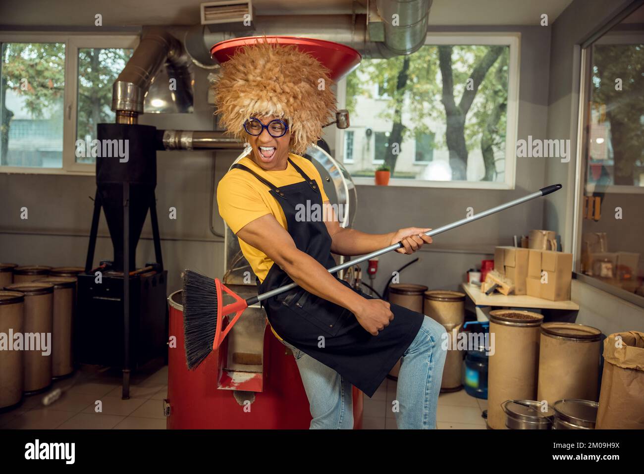 Cleaner having fun doing the cleaning at the coffee roastery Stock ...