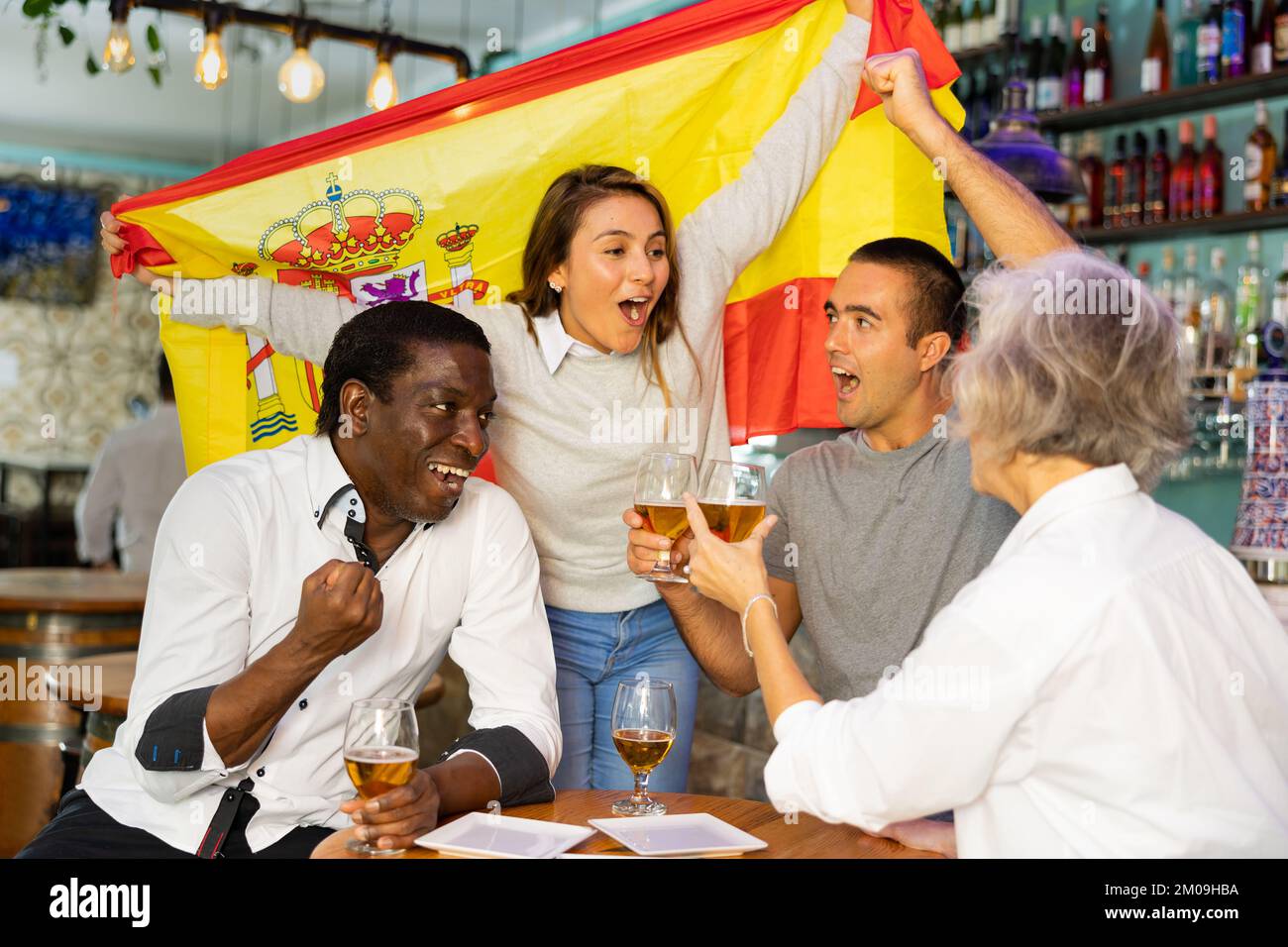 Men and women watching sport on tv together at bar, screaming cheerful ...