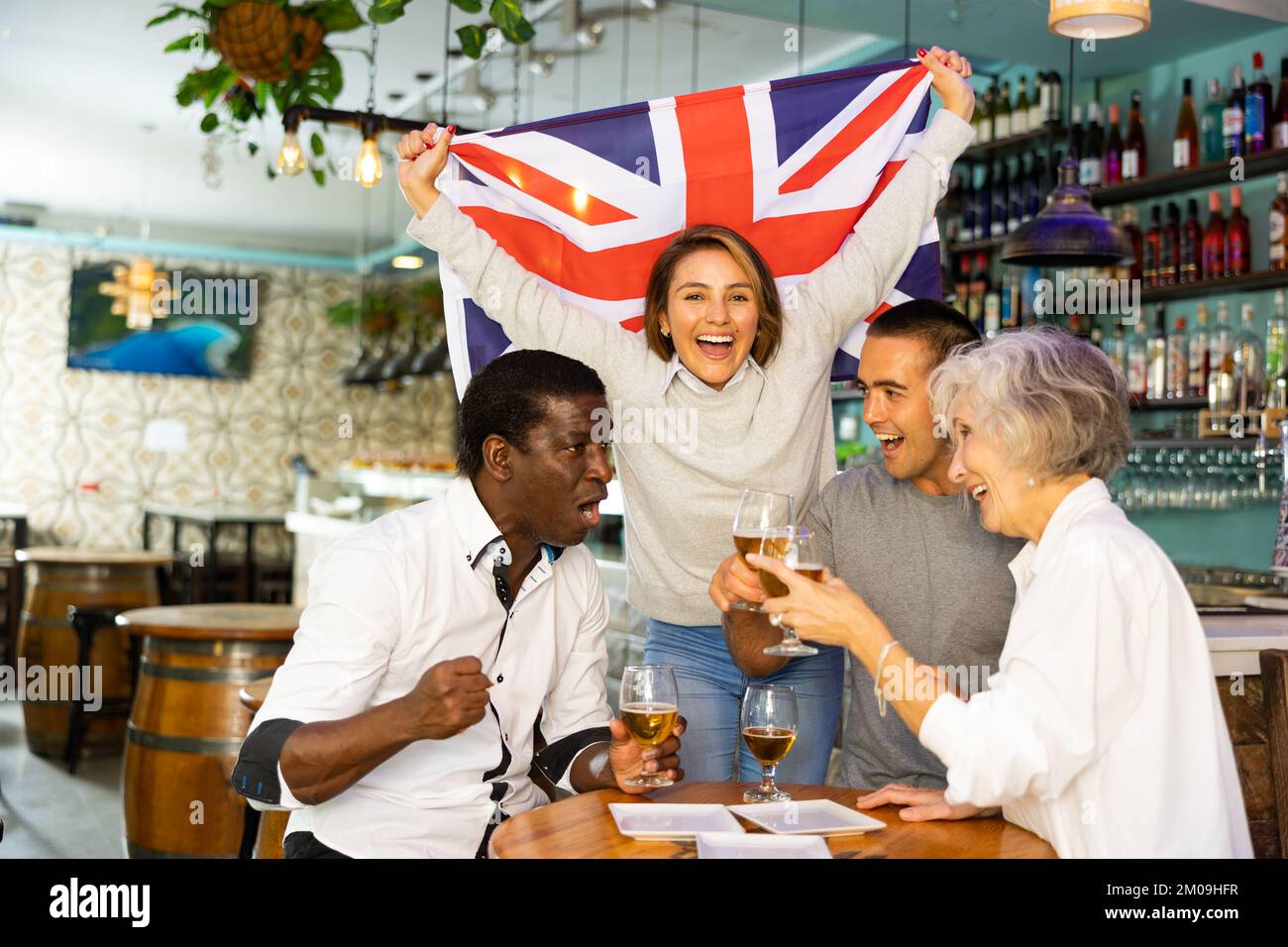 International group of people with UK flag toasting with beer, having ...
