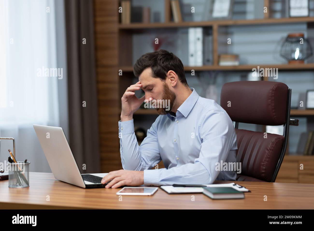 Mature pensive sad businessman working inside office, boss using laptop ...