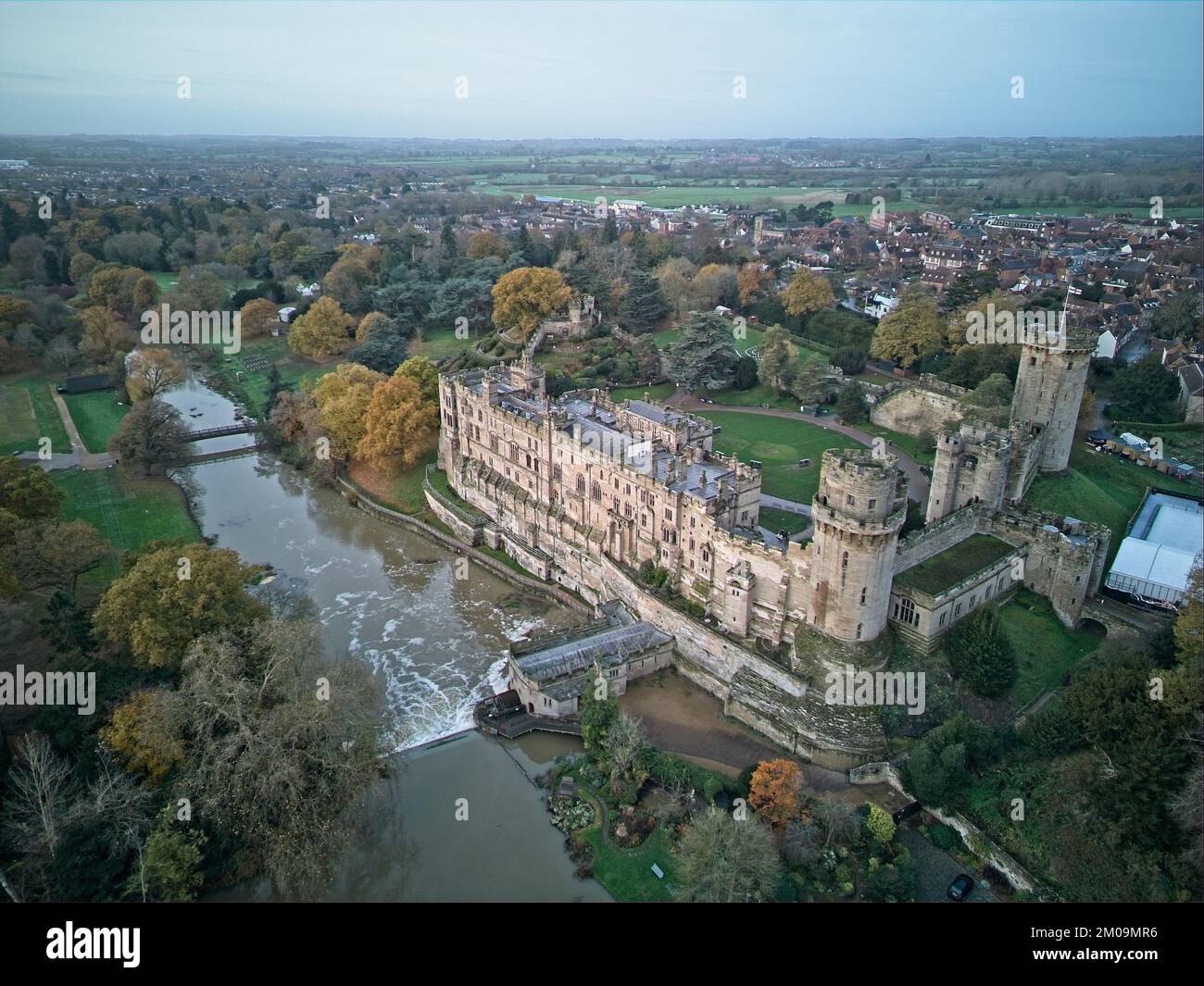 An aerial shot of an old traditional Warwick Castle surrounded by trees ...