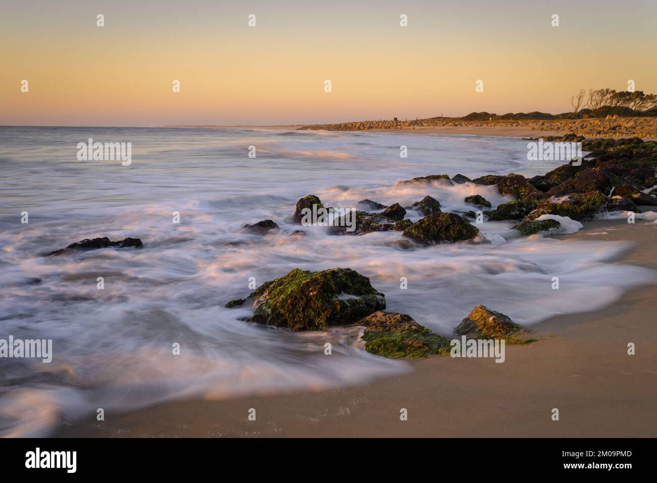 A long exposure of waves washing the shore and the rocks under the ...
