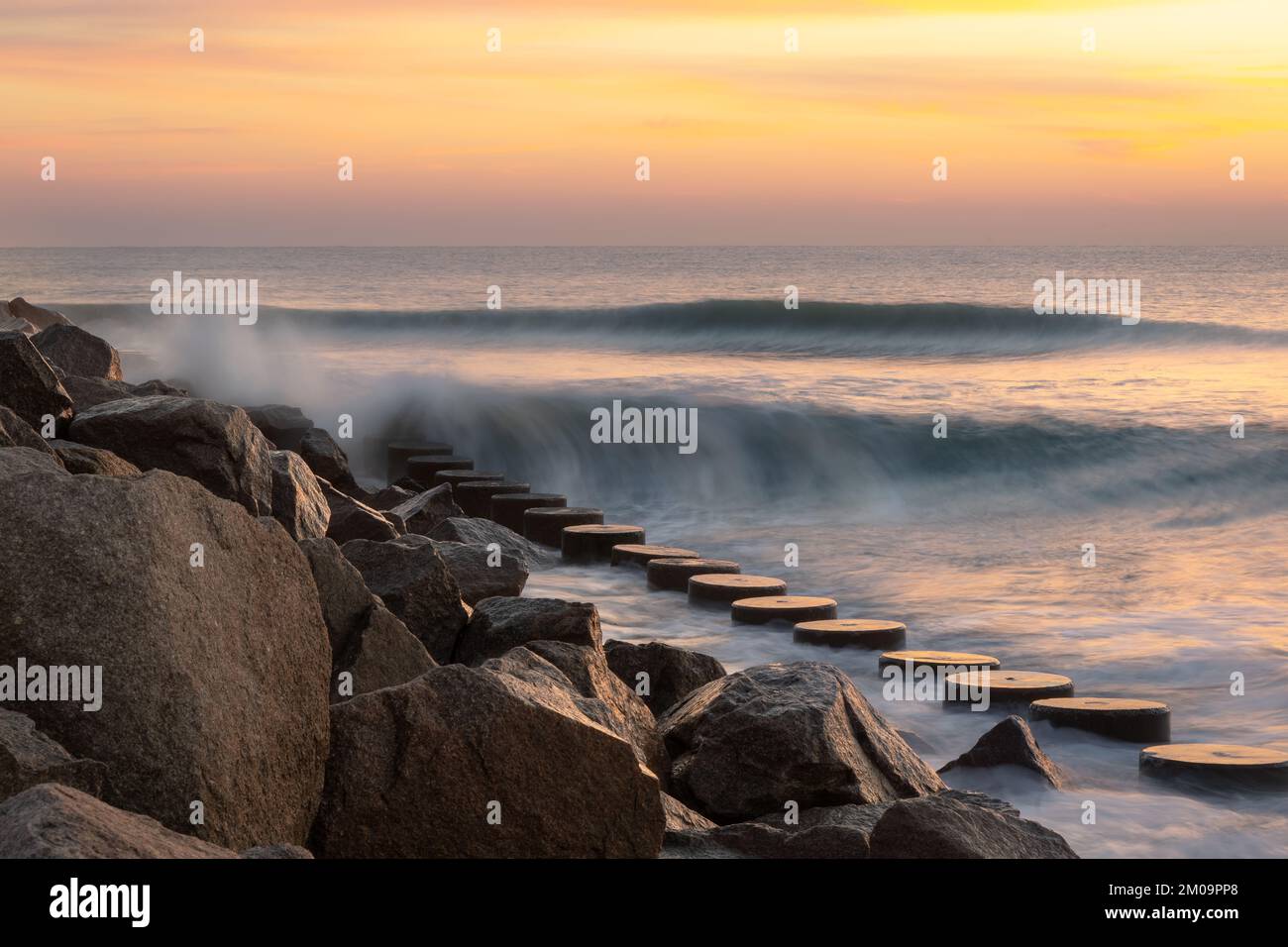 A long exposure of waves at Fort Fisher State Park at a pink and scenic ...
