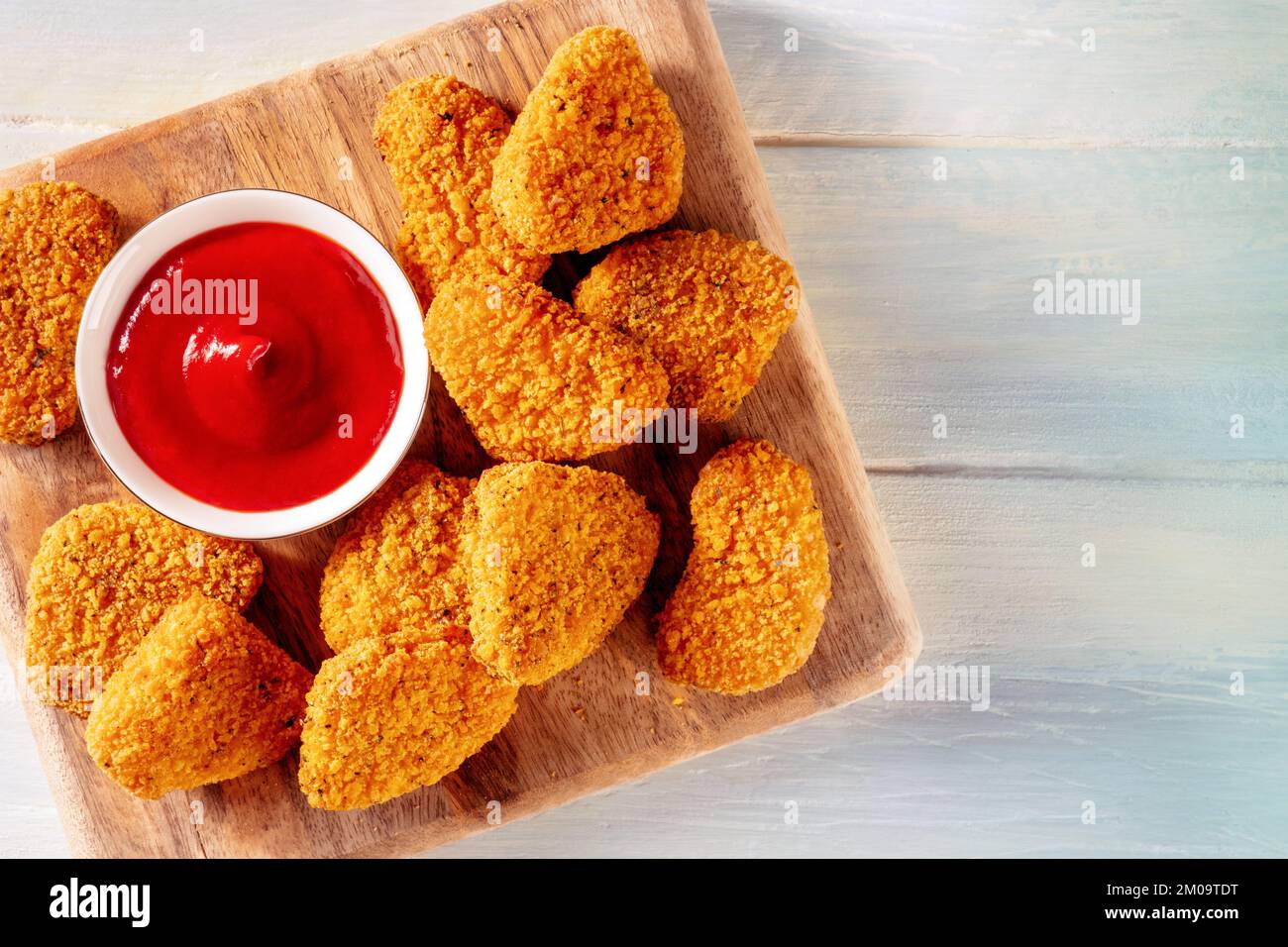 Chicken nuggets with ketchup sauce on a rustic wooden background ...