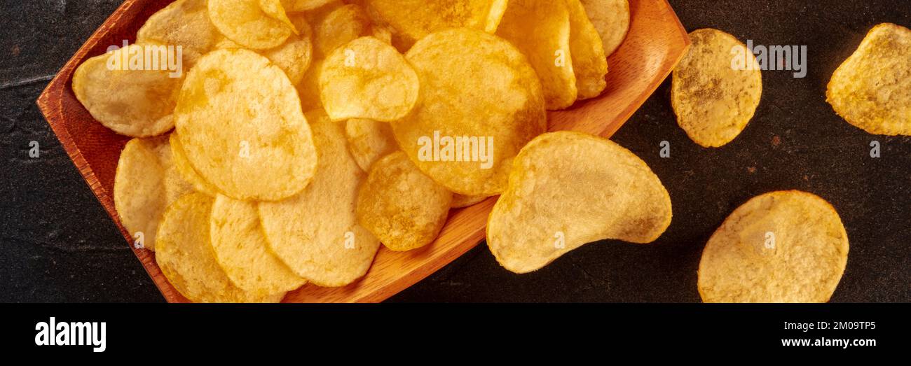 Potato chips or crisps panorama, a salty snack close-up, overhead flat ...