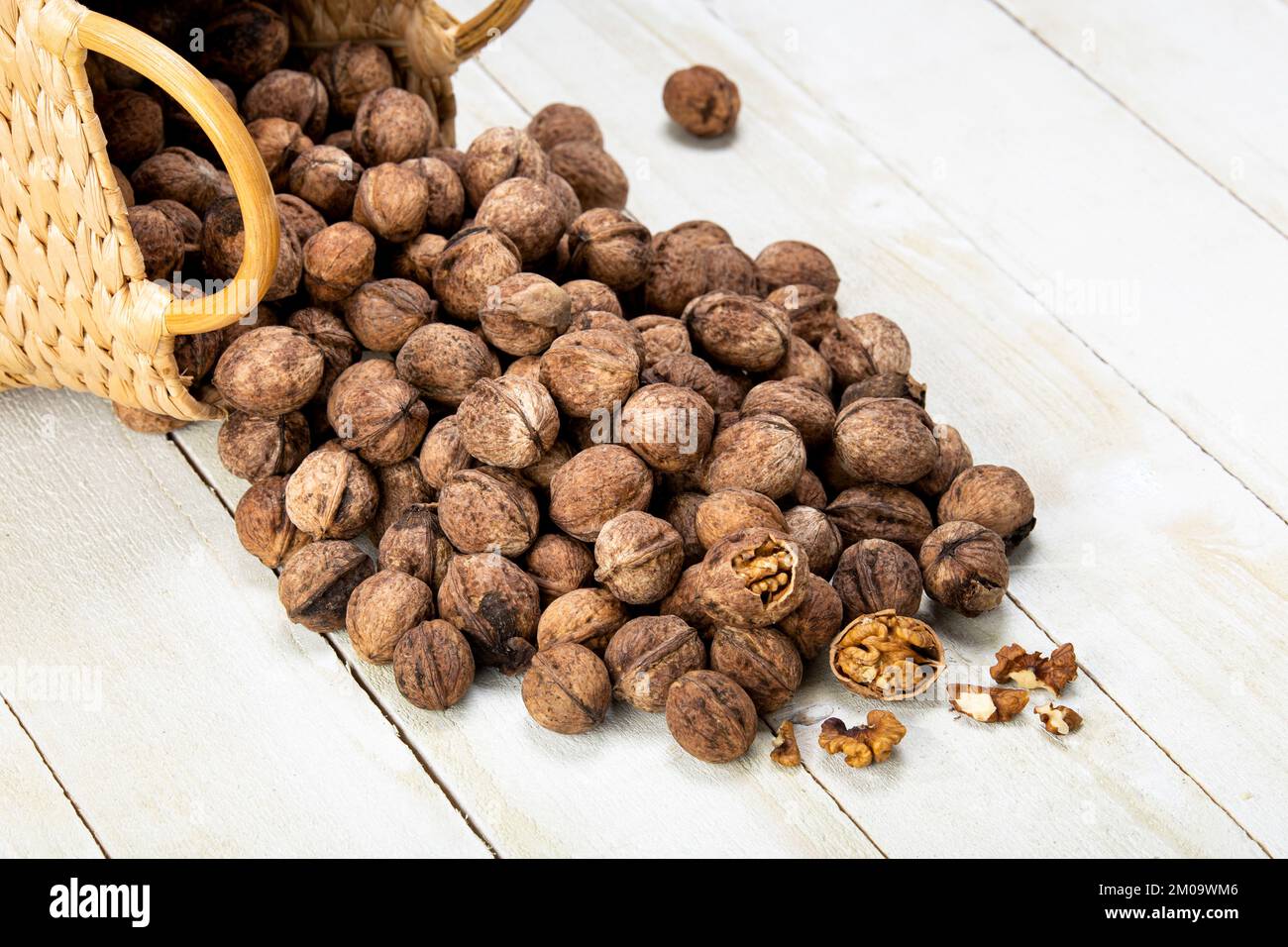 Stacked walnuts from basket on white wooden table - walnut harvest ...