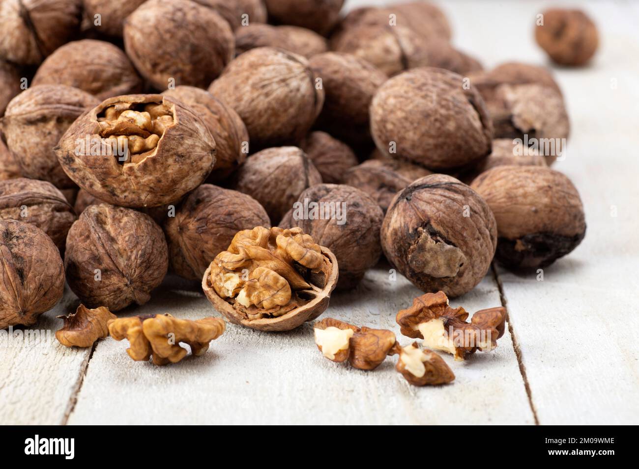 Stacked walnuts from basket on white wooden table - walnut harvest ...