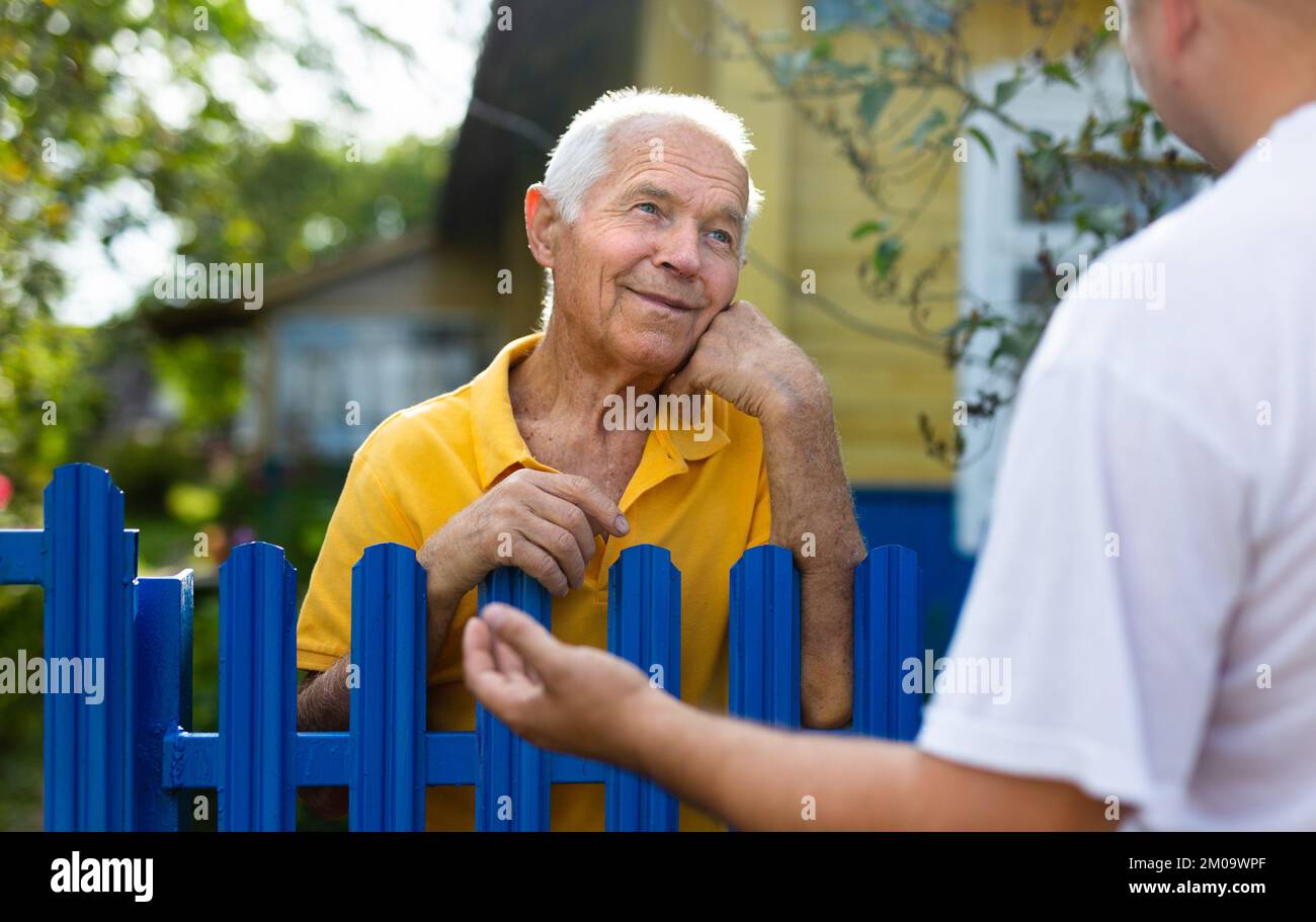 Old man talking with his neighbour Stock Photo - Alamy