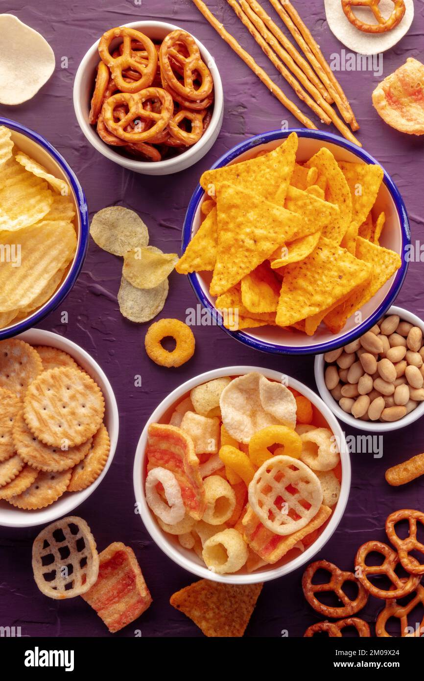 Salty snacks, shot from above. A table of assorted appetizers in bowls ...