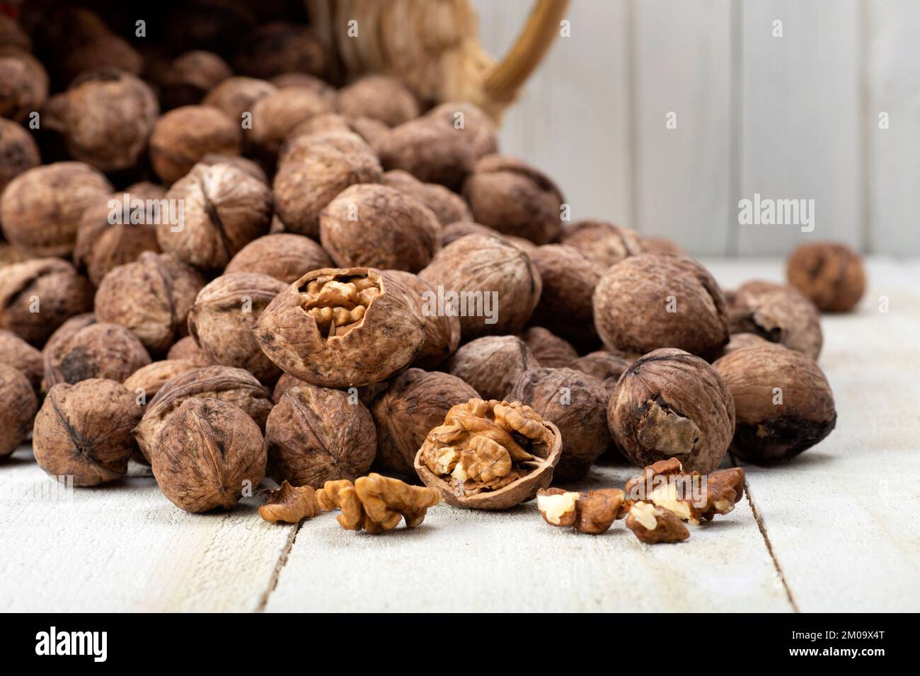 Stacked walnuts from basket on white wooden table - walnut harvest ...