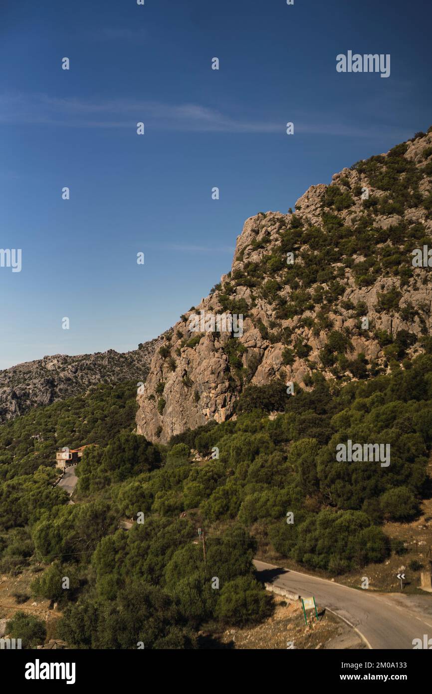 A vertical shot of rocky mountains under a blue sky in the countryside ...