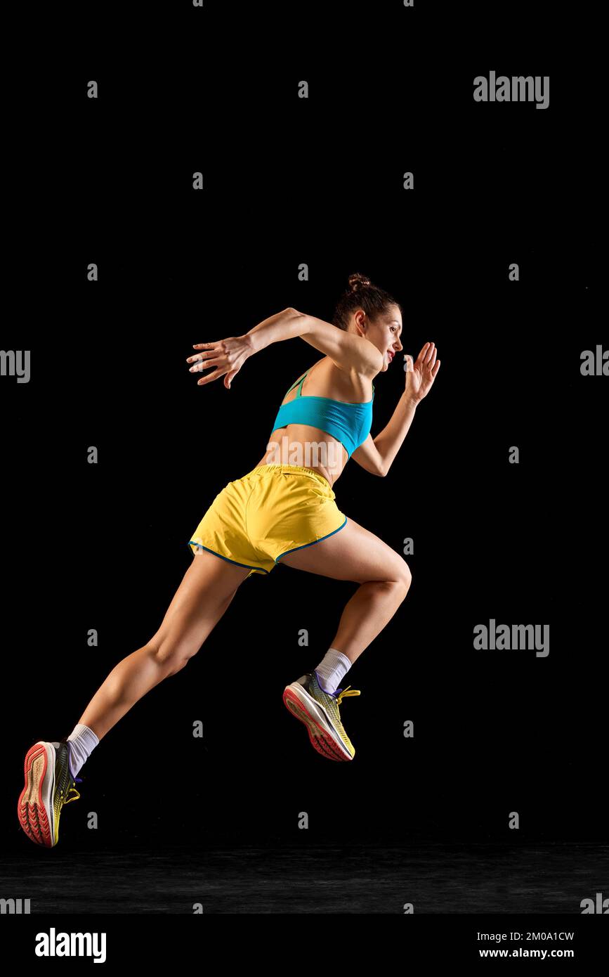 Back view. Sportive muscled woman, professional runner running away ...