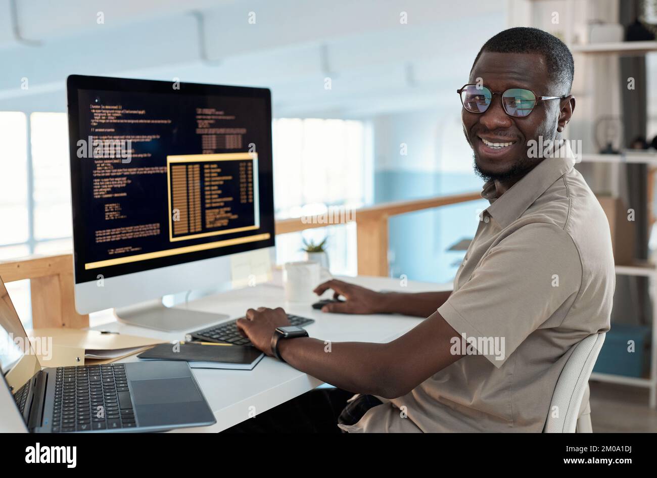 Portrait of smiling software engineer working on computer in office of IT company Stock Photo ...