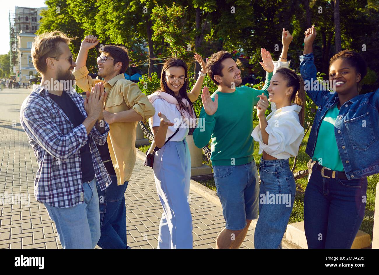 Happy young diverse people having lots of fun while dancing on a city street together Stock ...