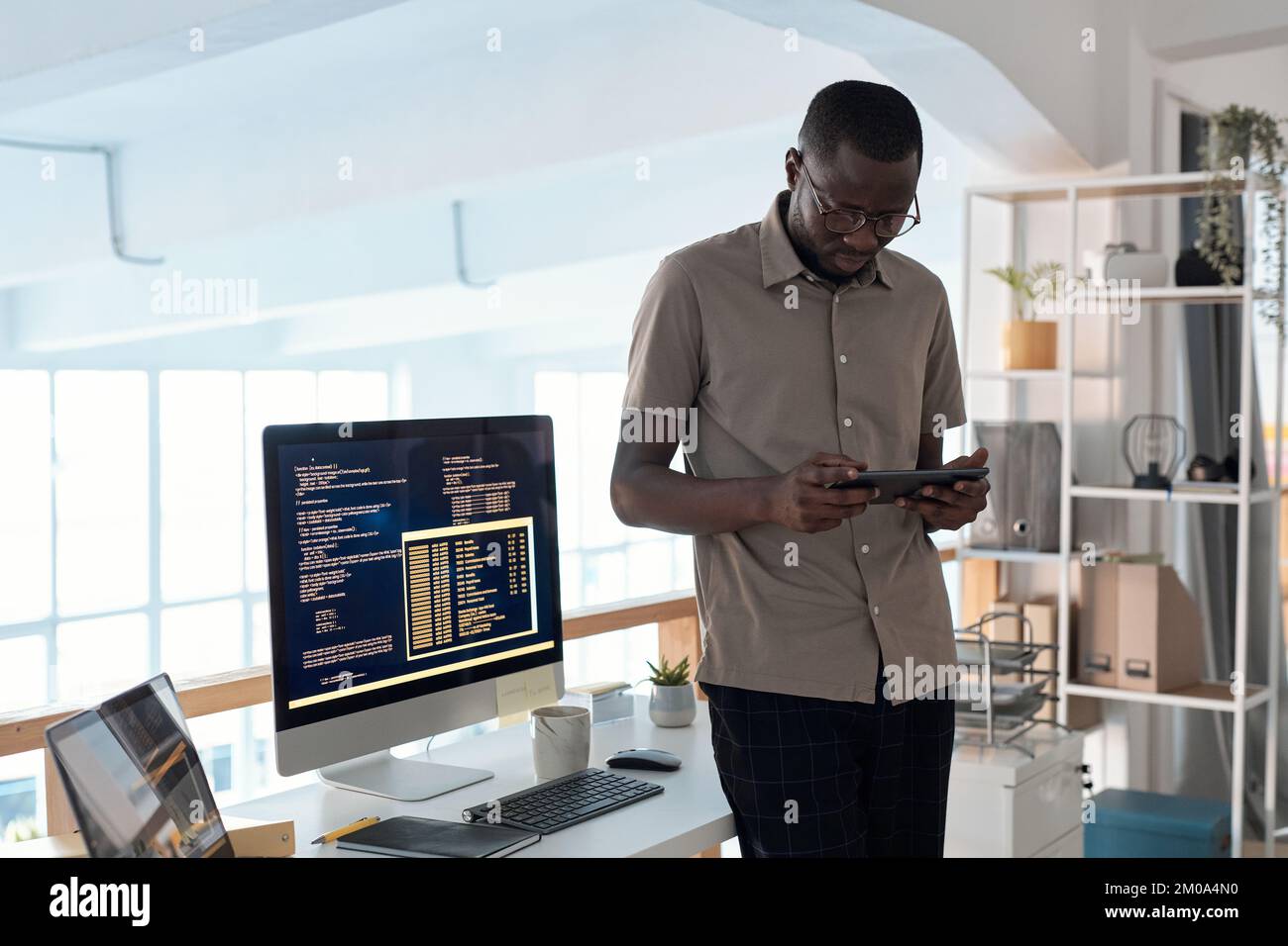 Serious software developer testing new application on digital tablet ...