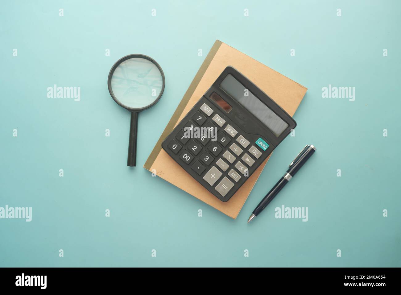 top view of black color calculator and notepad on color background ...