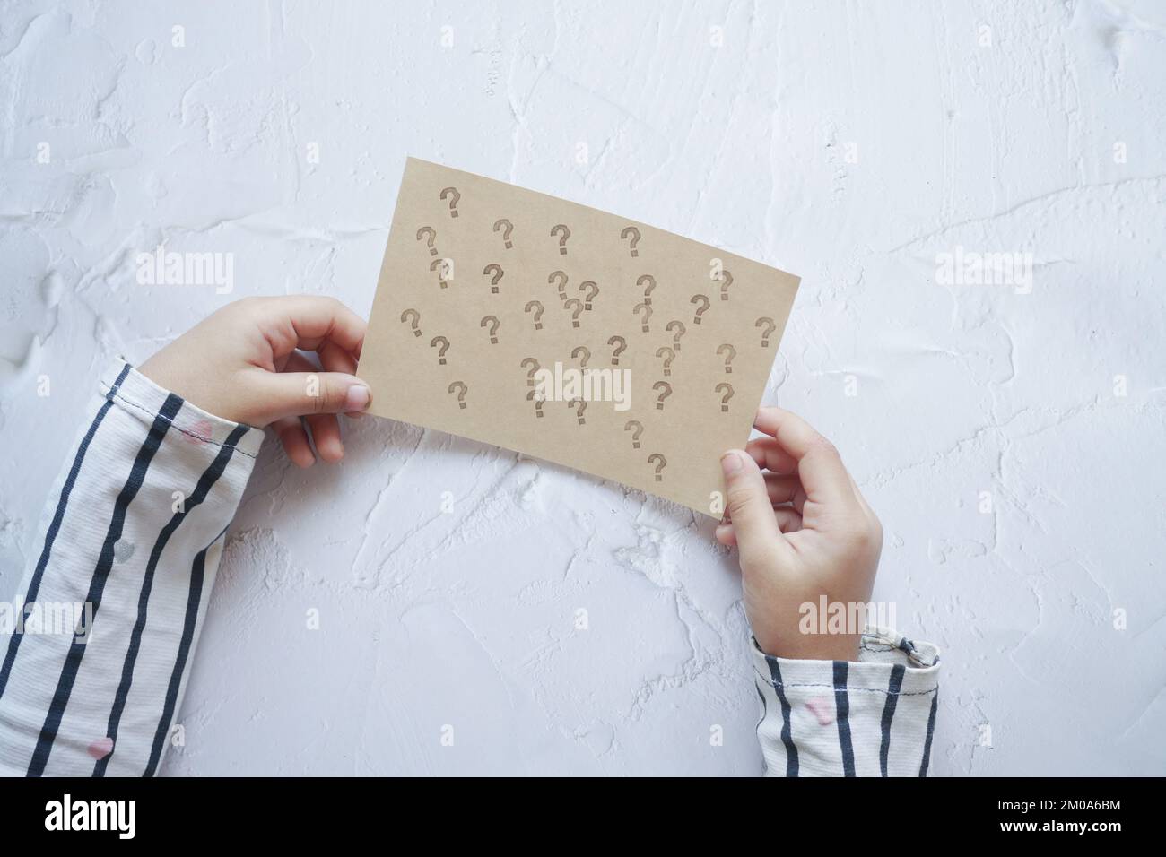 child holding a question mark paper on white background Stock Photo - Alamy