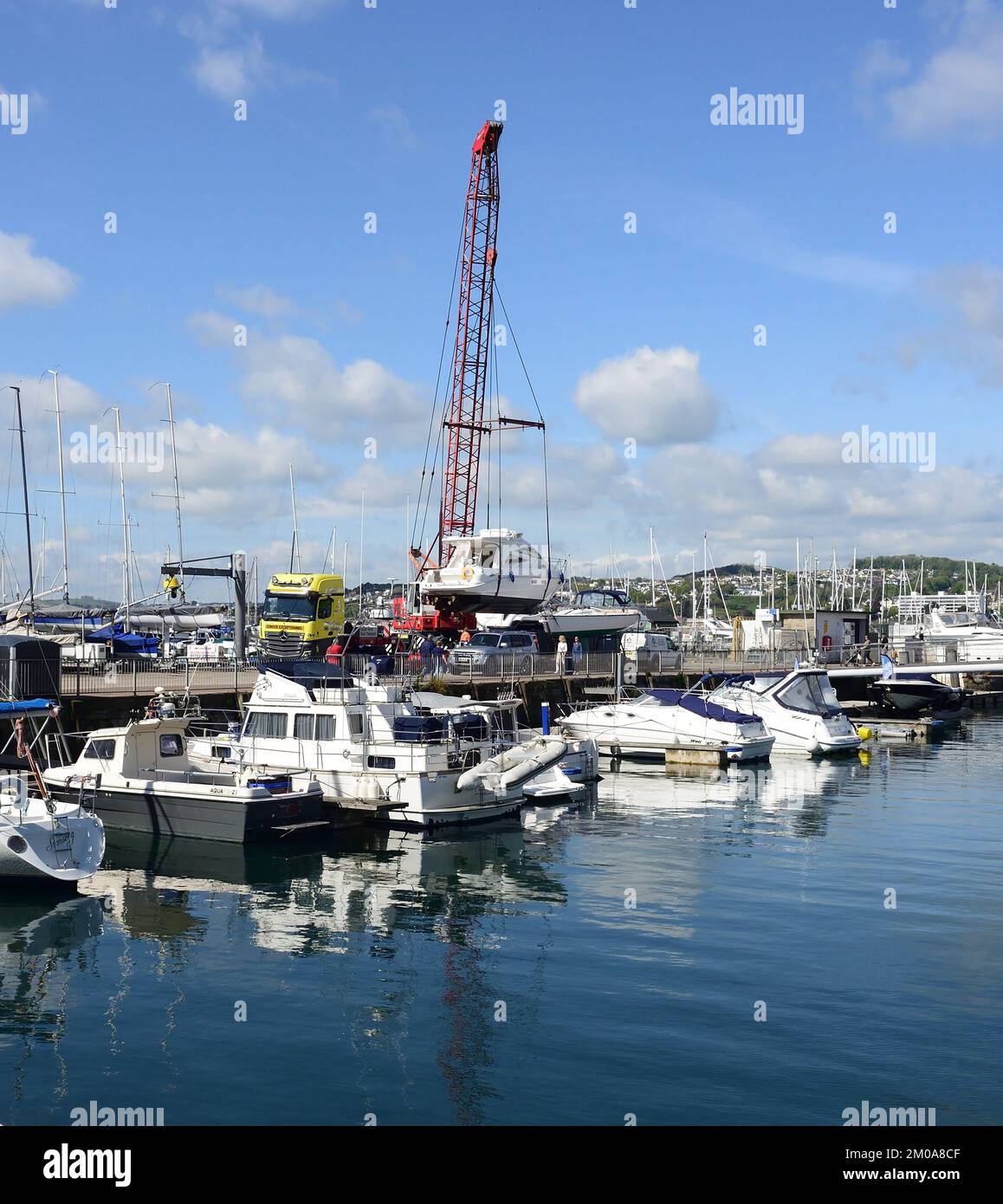 A boat being lifted onto a heavy goods vehicle in Torquay harbour ...