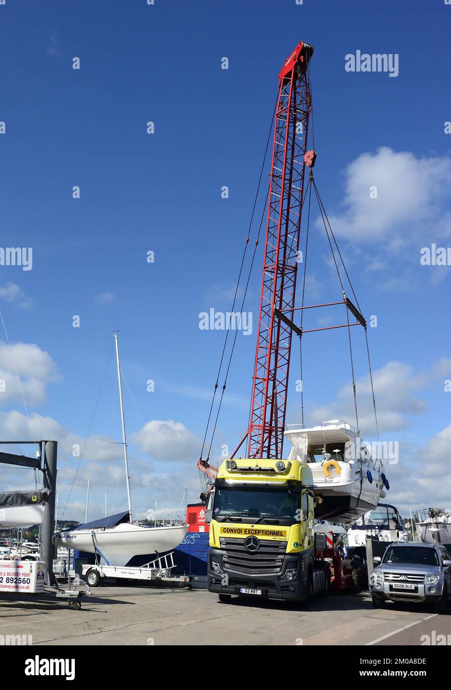 A boat being lifted onto a heavy goods vehicle in Torquay harbour ...