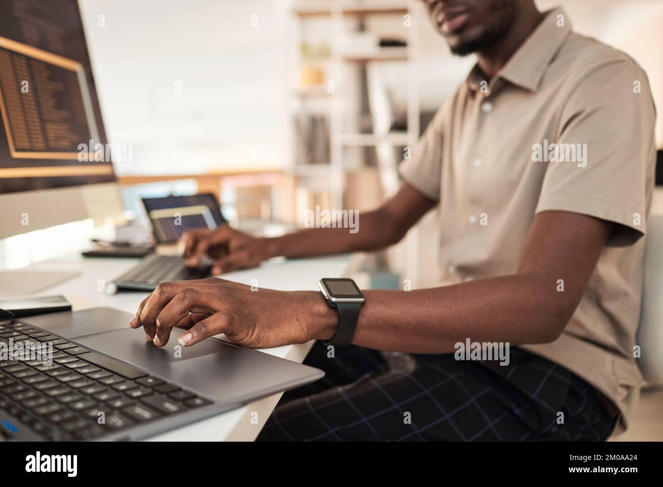 Software developer wearing smartwatch when working on computer in ...