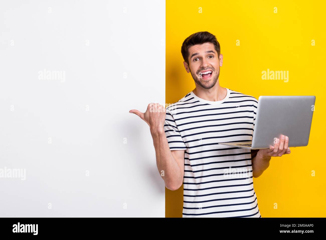 Photo of charming impressed guy dressed striped t-shirt working modern ...