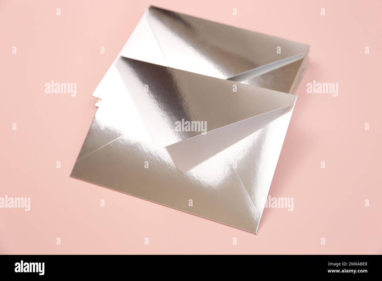 Mirror or Silver paper festive envelopes on pink background, top view ...
