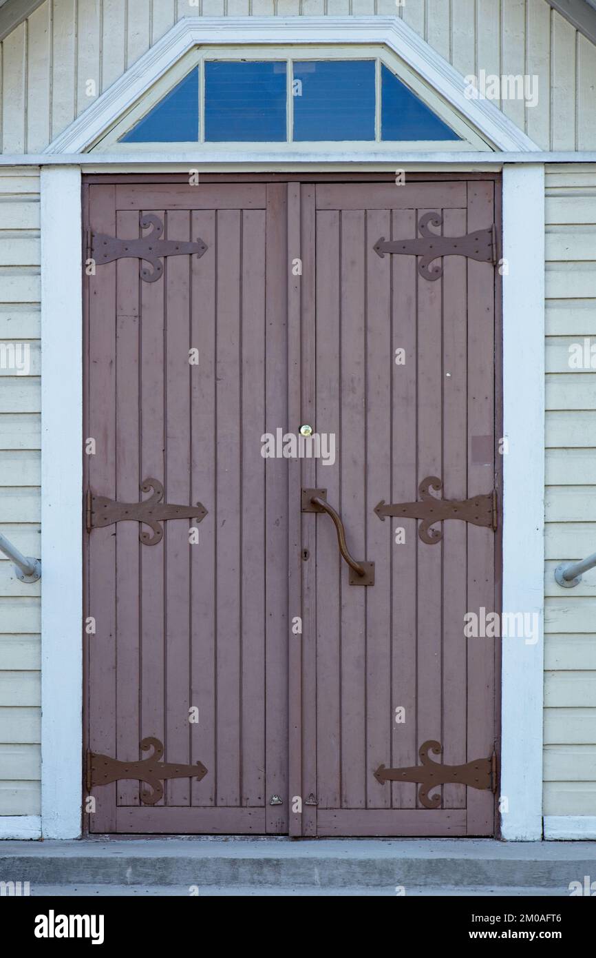 Brown painted old wooden door with decorative iron hinges on wooden ...