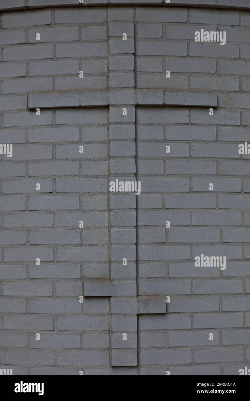 Closeup of a cross made of white bricks on white brick building wall ...