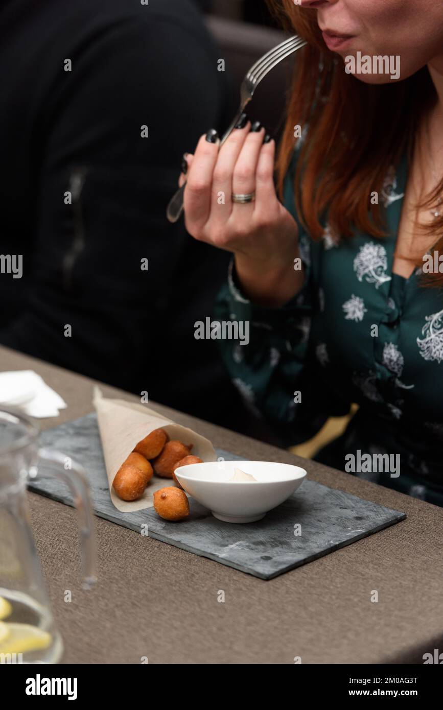 Beautiful breakfast. Women eating Croatian donuts with potatoes and ...