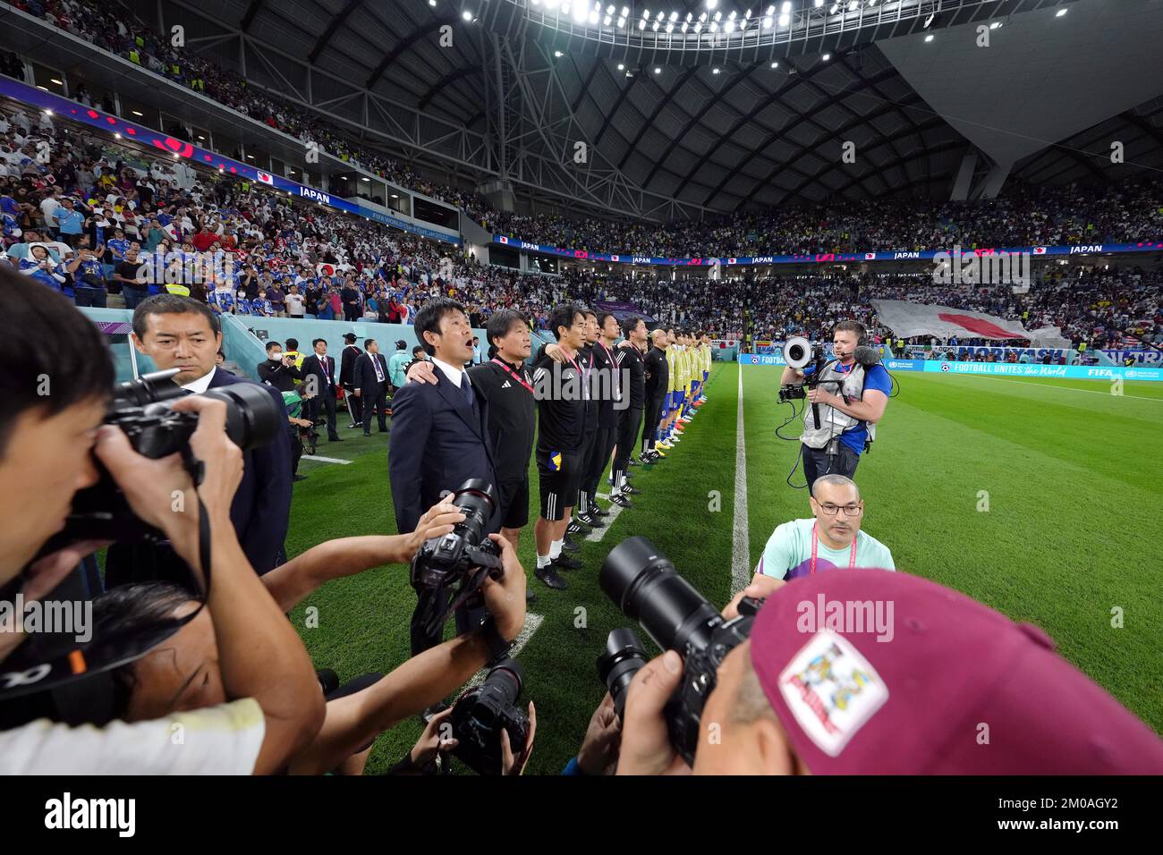Japan manager Hajime Moriyasu the back room staff and substitutes sing ...