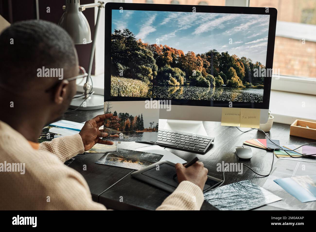 Edor looking at reference photo when coloring photo of landscape on ...