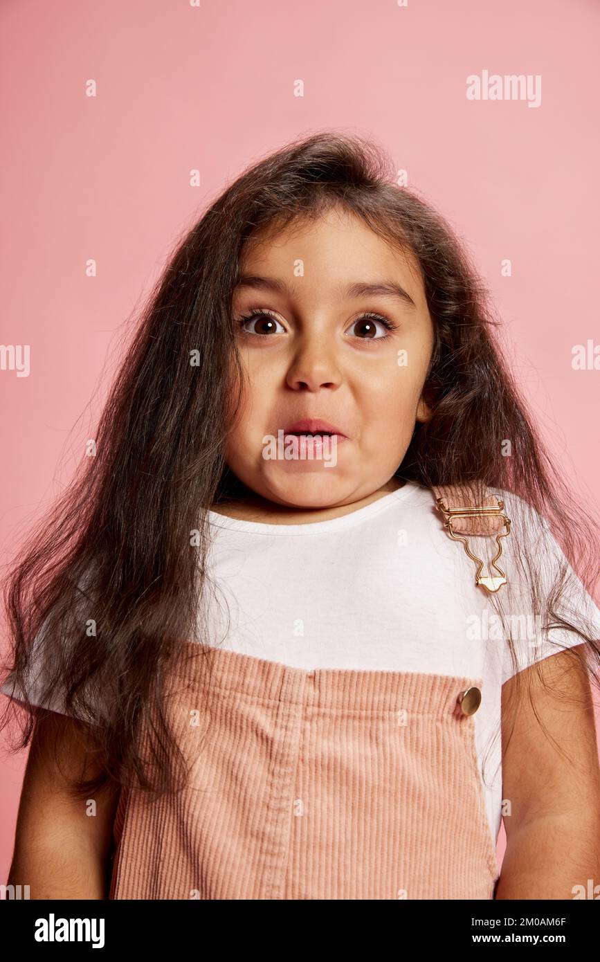 Portrait of cute little girl, child, posing with happy shocked face ...