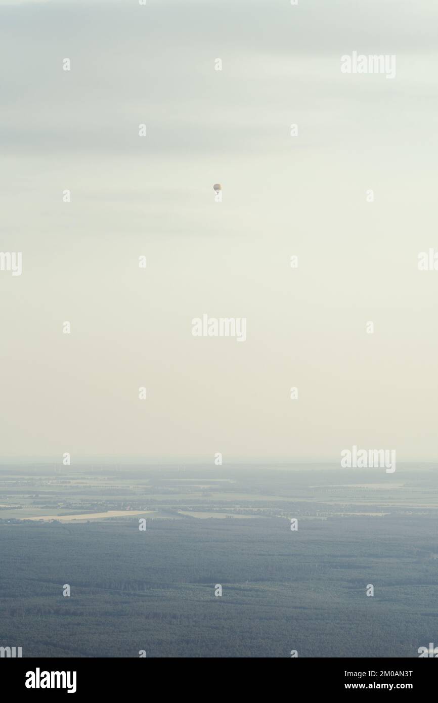 A scenic view of a balloon in the sky over a valley during sunset Stock ...