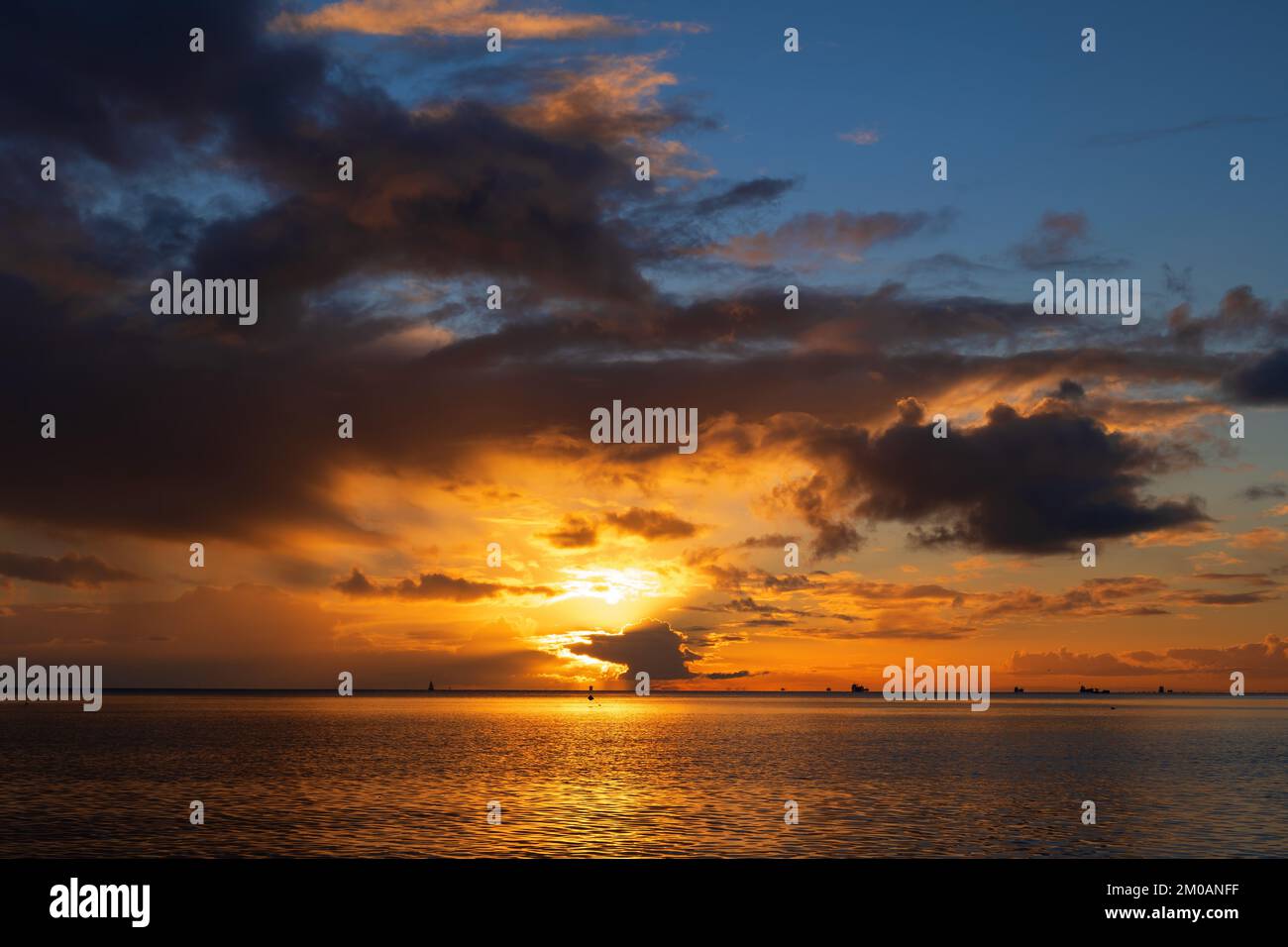 Sunrise cloudscape over the Baltic Sea with sun shining through rain ...