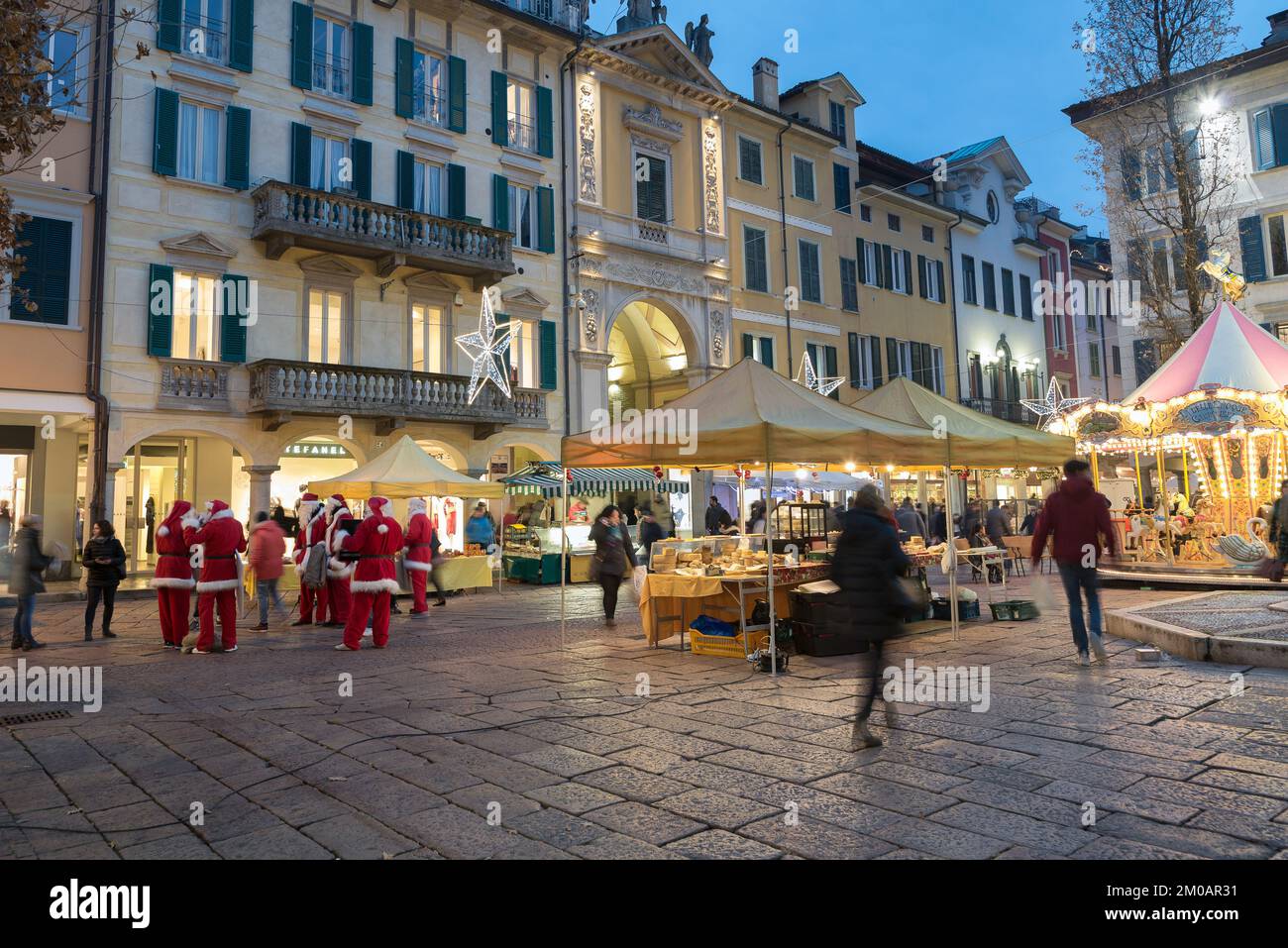 City street at dusk with Christmas lights and stalls. Historic center ...
