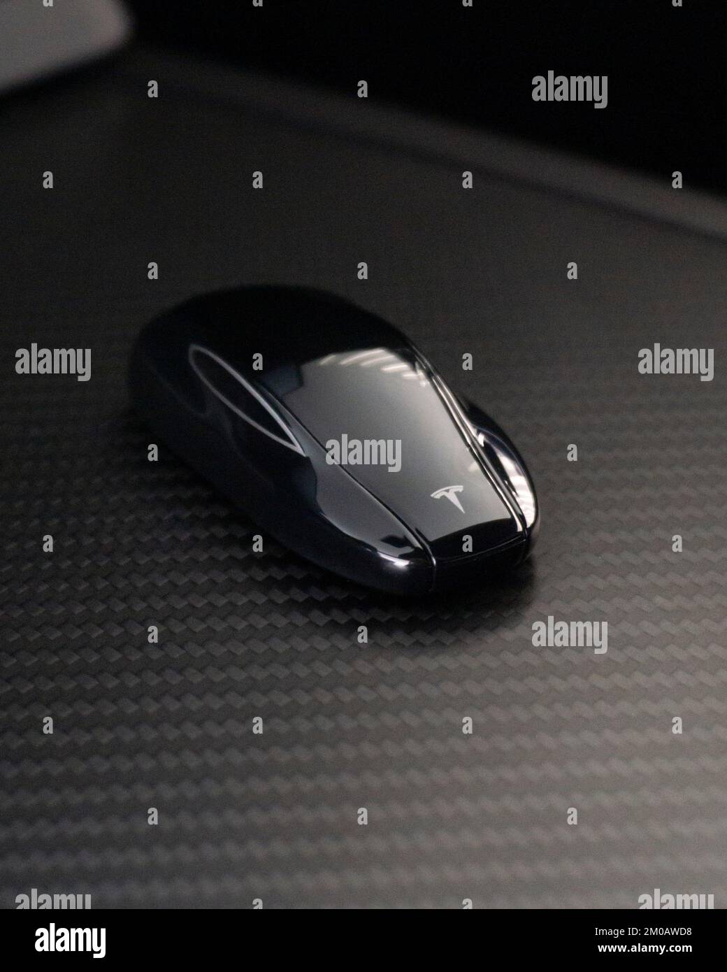 A vertical shot of a Tesla Model S Plaid key on the carbon fiber center ...