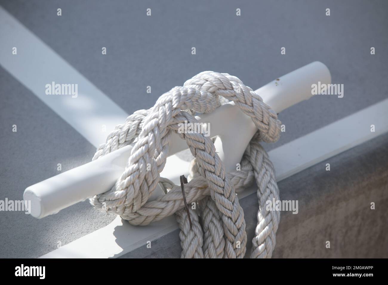 Stainless steel mooring bollard with knotted rope mounted on the deck ...