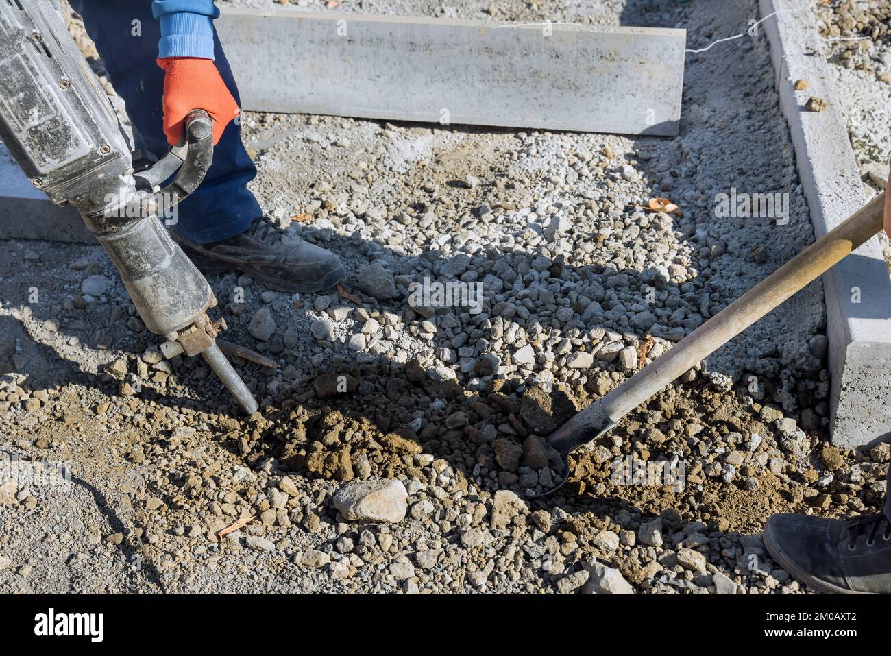 Construction workers using jackhammer to dig out concrete surface on ...