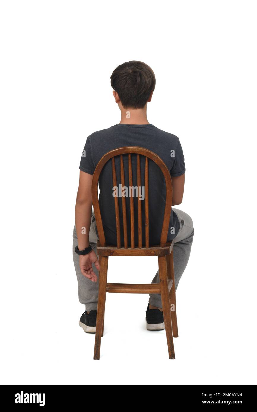 rear view of teenage boy sitting on a chair with white background Stock ...