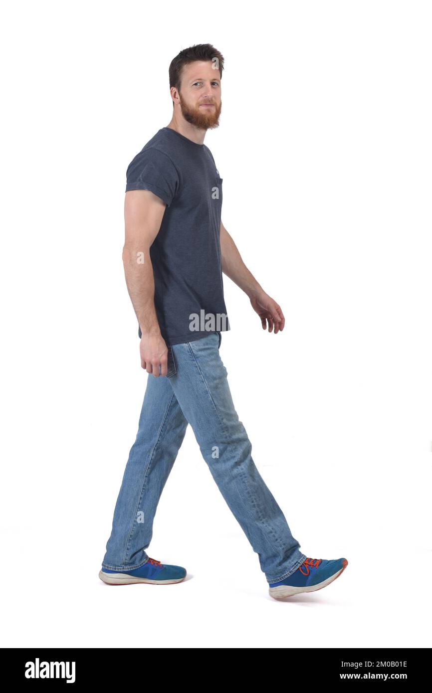 side view of a man walking and looking at camera on white backgound ...