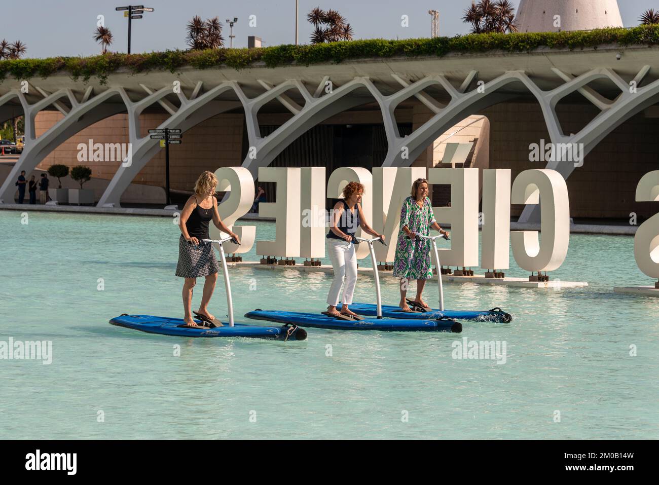 Three women on paddle boards, hired at the City of Arts and Sciences in ...