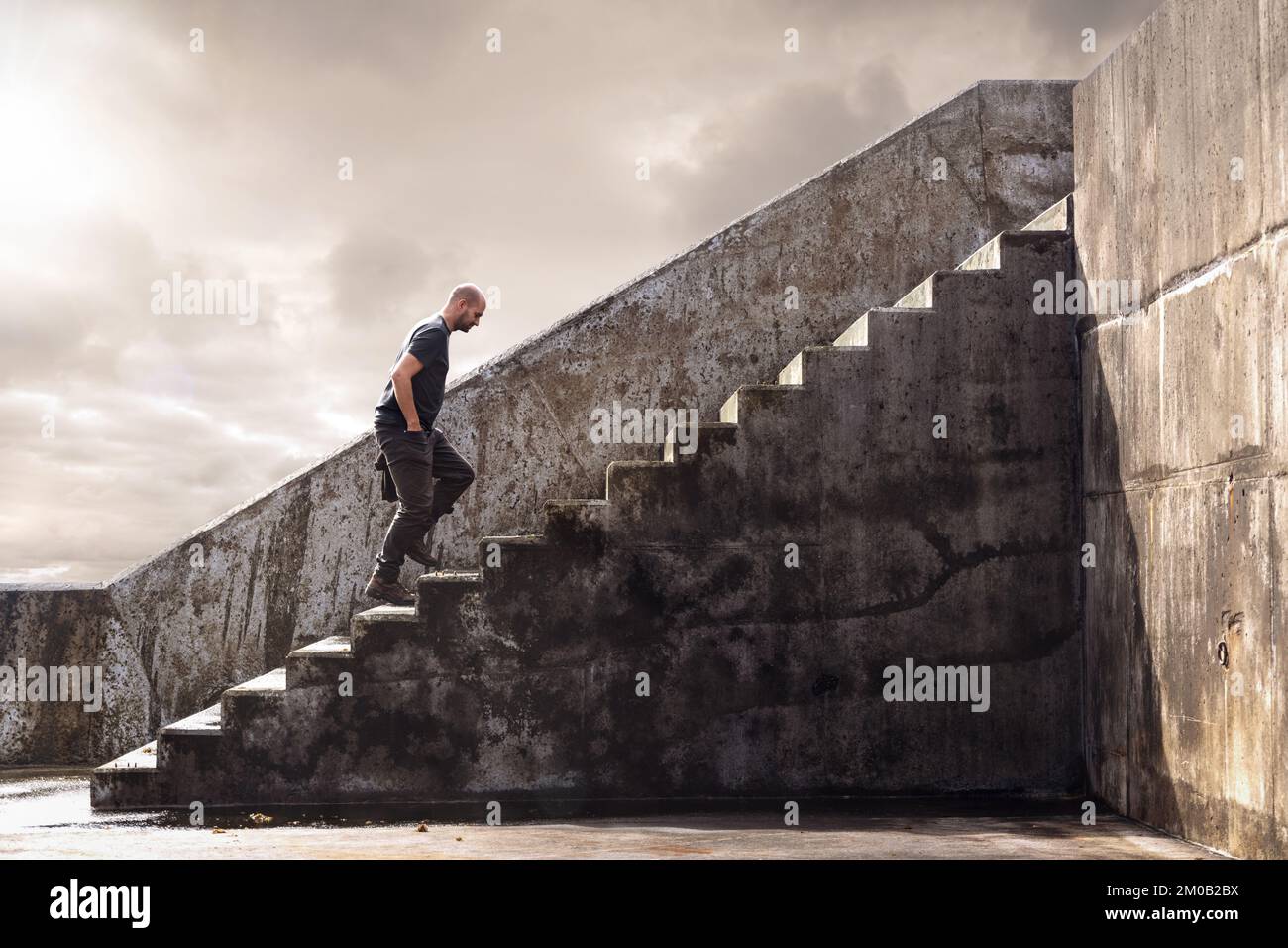 Man climbing concrete stairs Stock Photo - Alamy