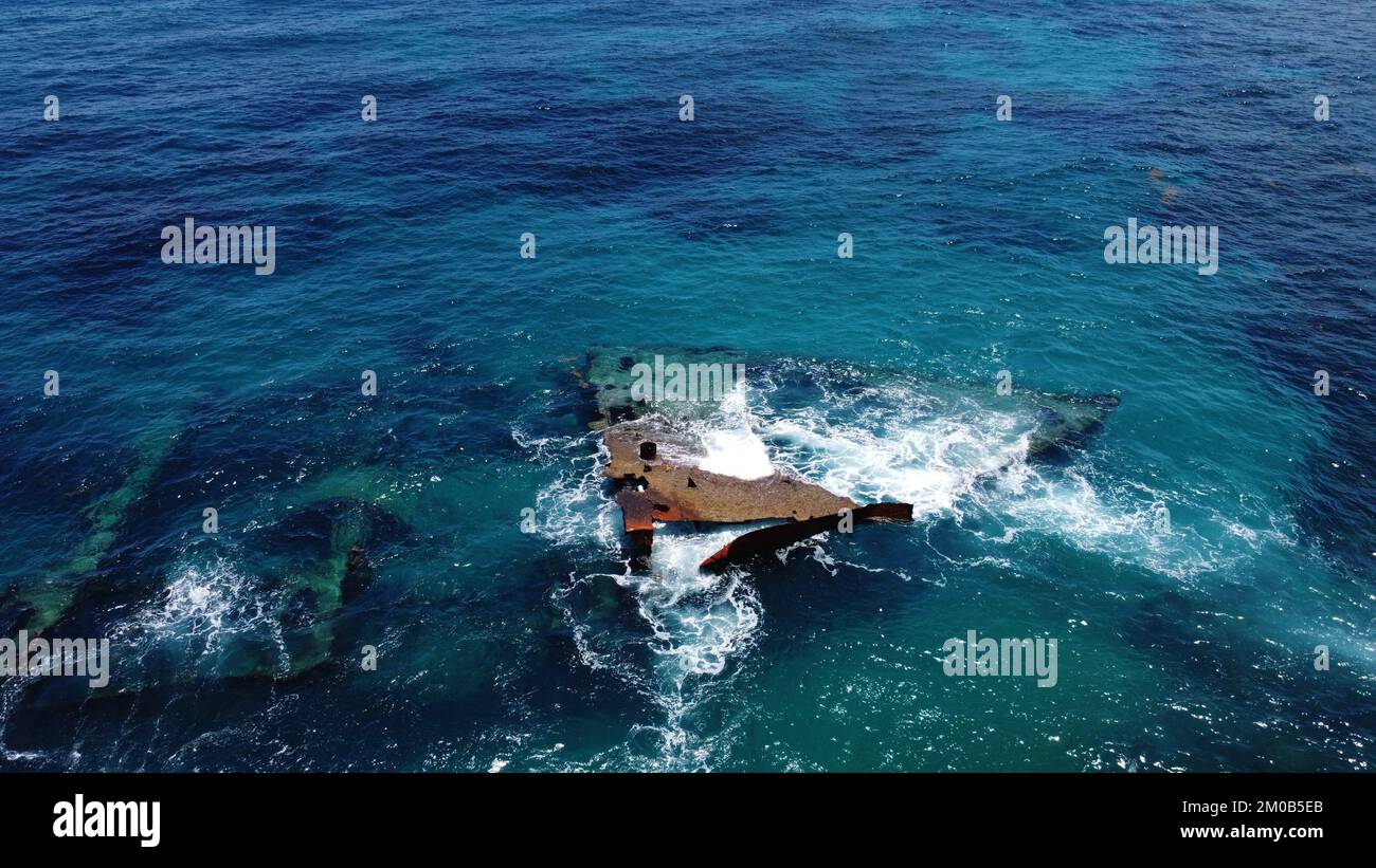 A beautiful view of a shipwreck in a sea with small waves during ...