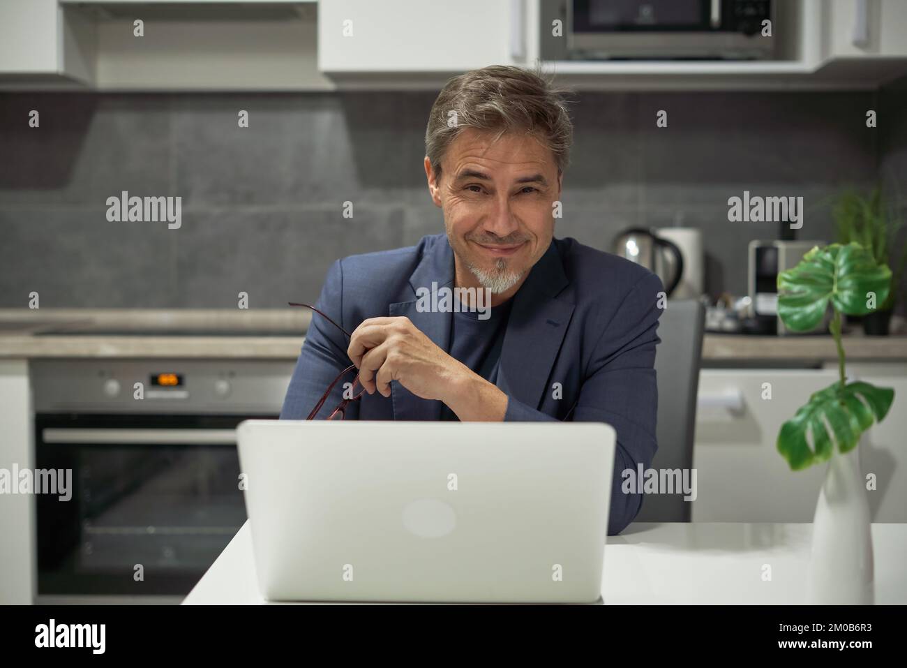 Portrait of businessman. Older man tele working with laptop computer at ...