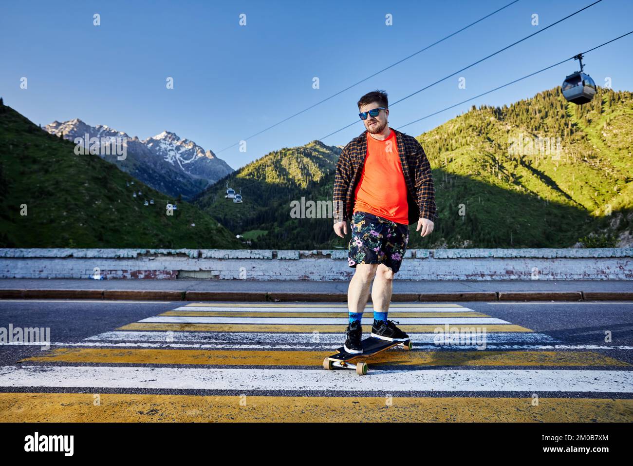 Bearded man Skater ride in the mountain road on his longboard in Medeo ...
