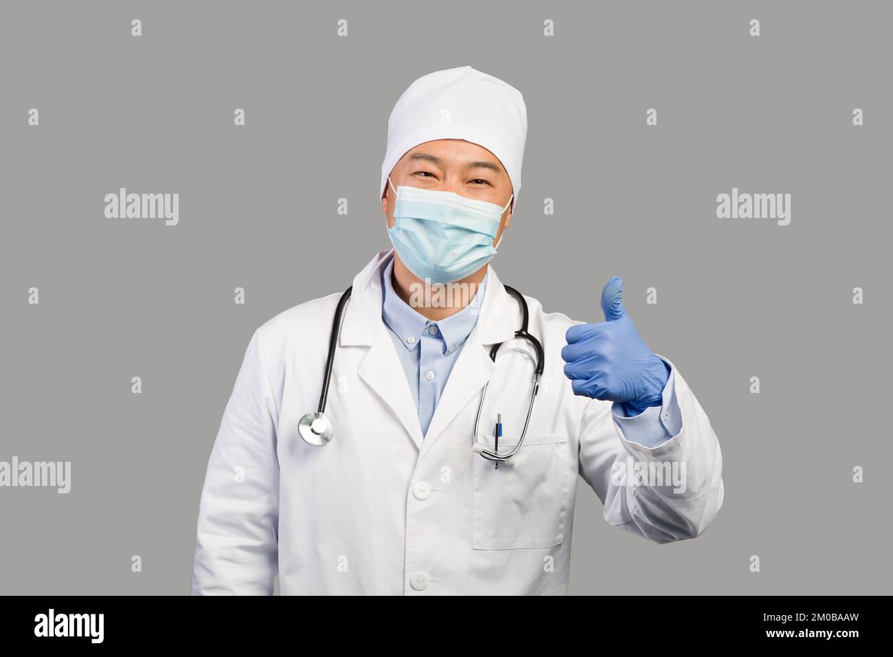 Smiling middle aged chinese male therapist in white coat, protective ...