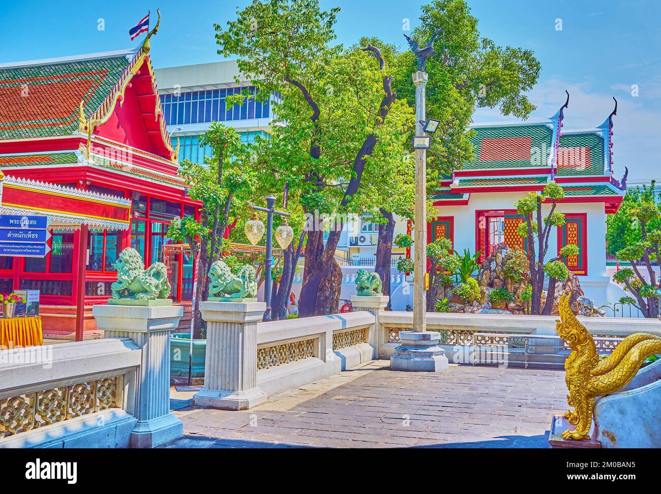 The colorful tiled roofs and golden carved Naga serpents of Wat ...